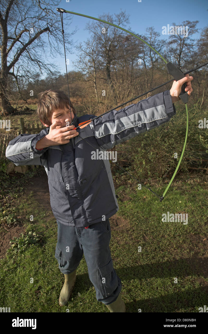 Boy firing arrow from bow Stock Photo - Alamy
