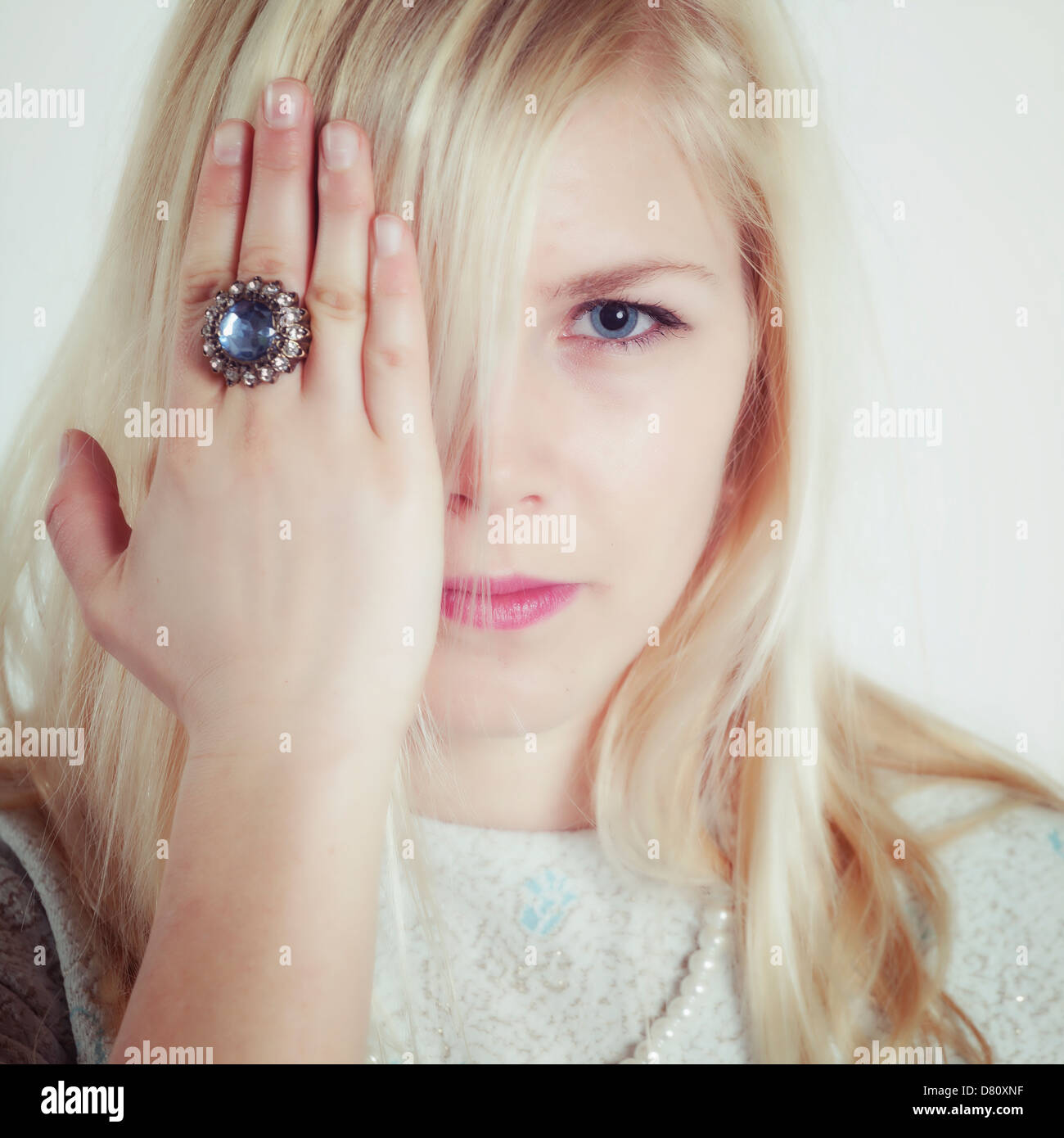 portrait of a beautiful young girl with one hand in front of her eye ...
