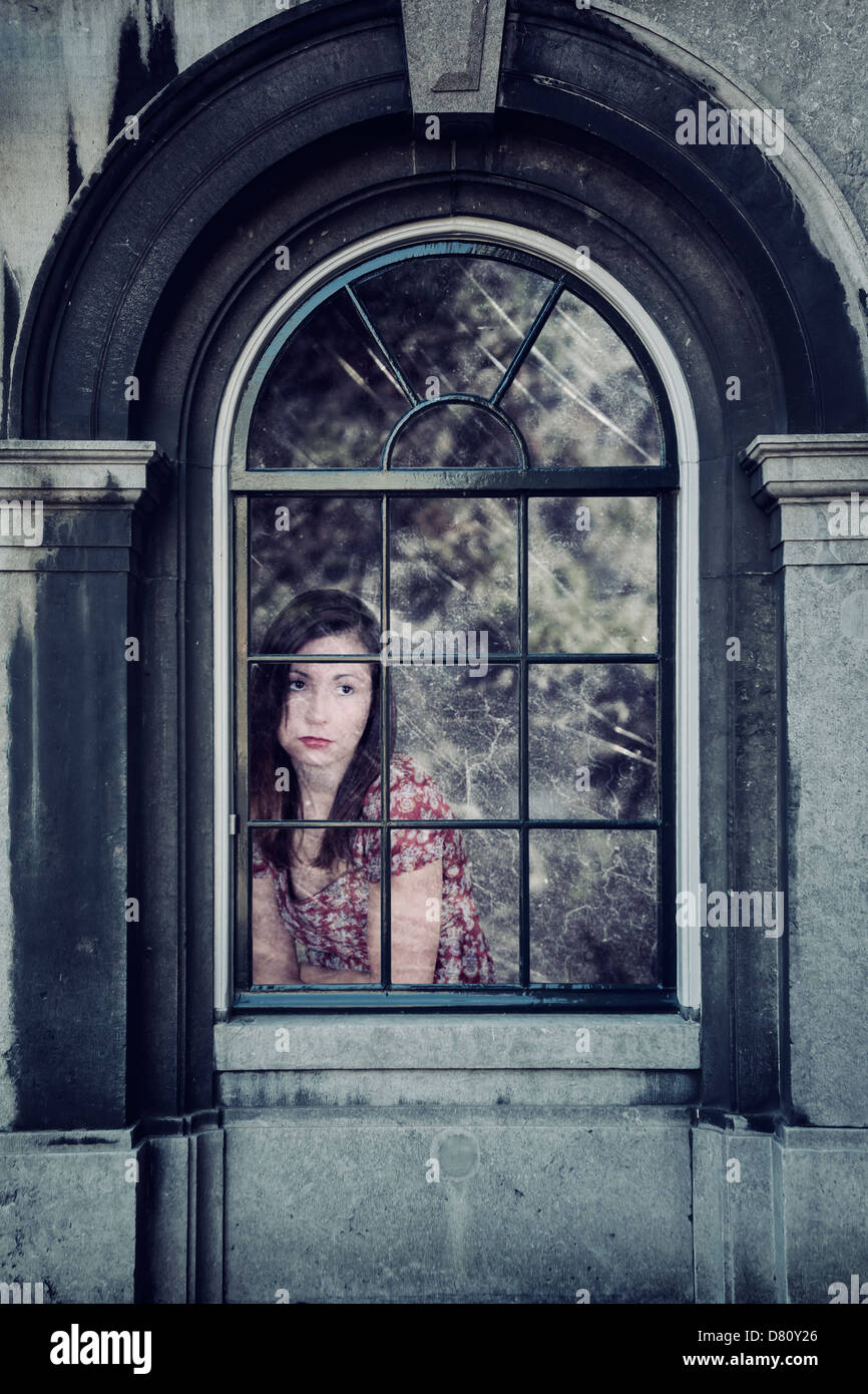 sad looking woman behind an old window Stock Photo - Alamy