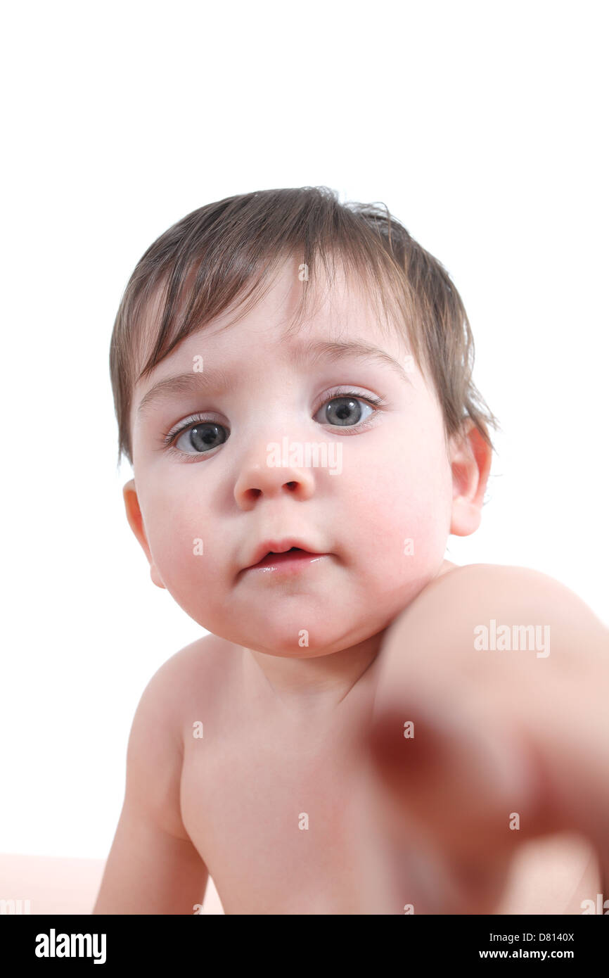 Baby looking and pointing at the camera isolated on a white background ...