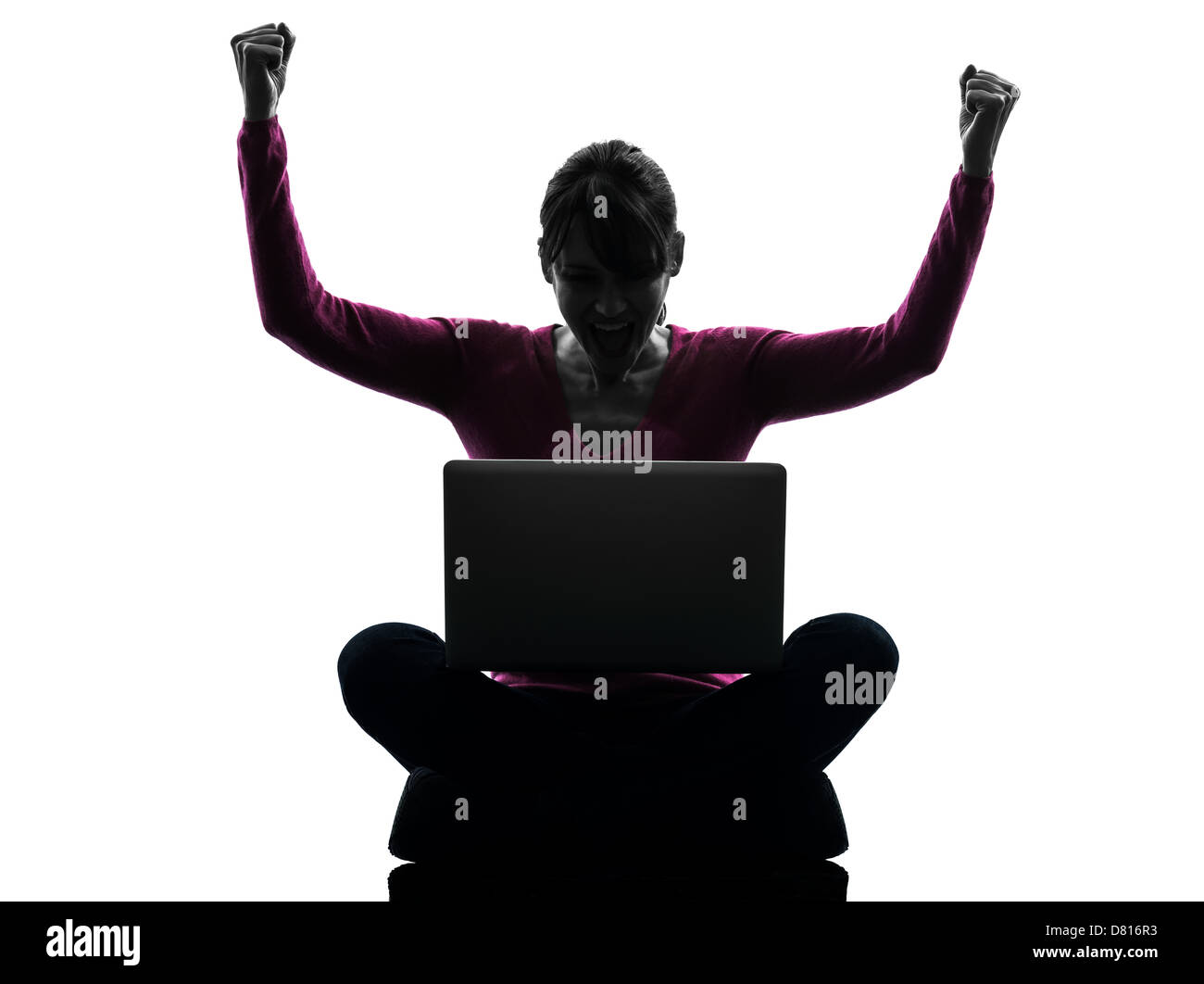 one woman happy winning computing laptop computer in silhouette studio ...