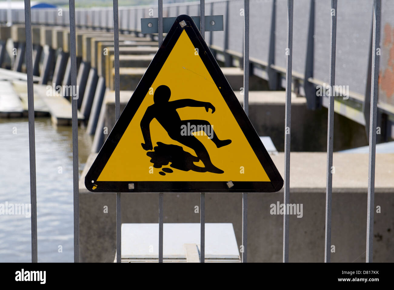 A warning sign indicating a slippery surface near the sluice gates of ...