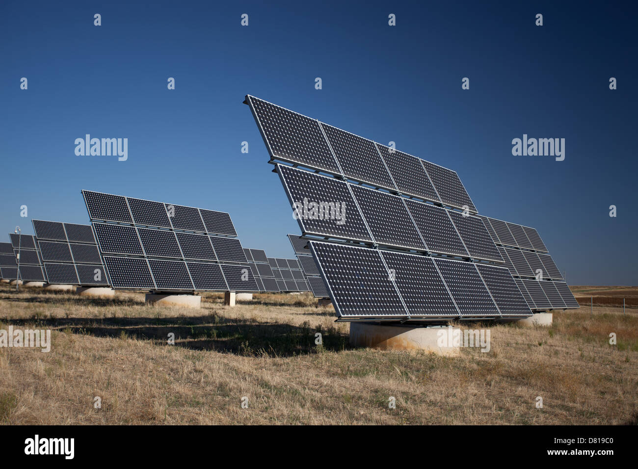Solar panels in a greenfield, over blue sky Stock Photo - Alamy