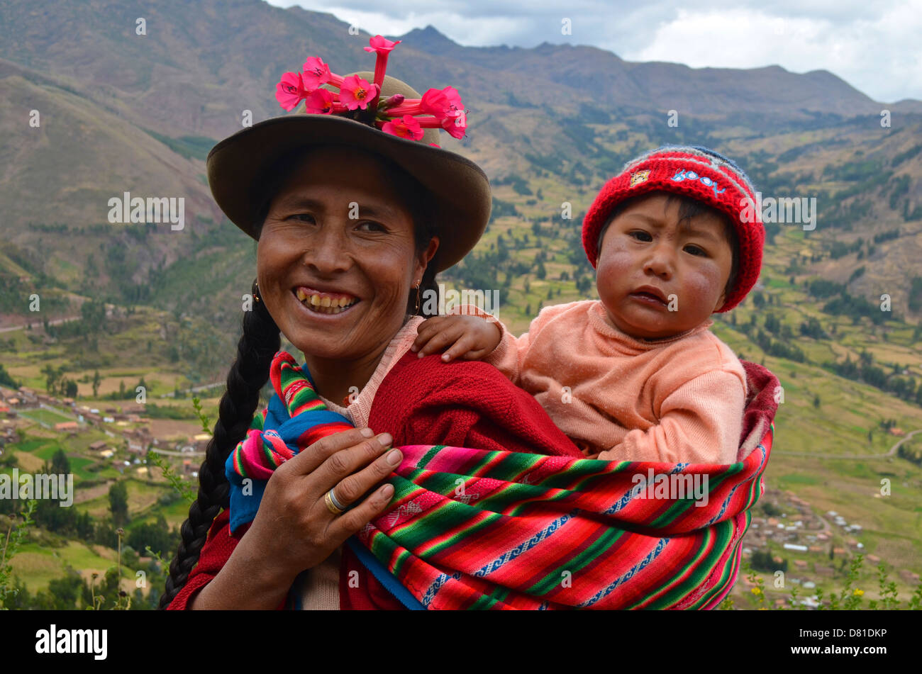 A mother smiles as she carries her baby son on her back in Cuzco, Peru ...