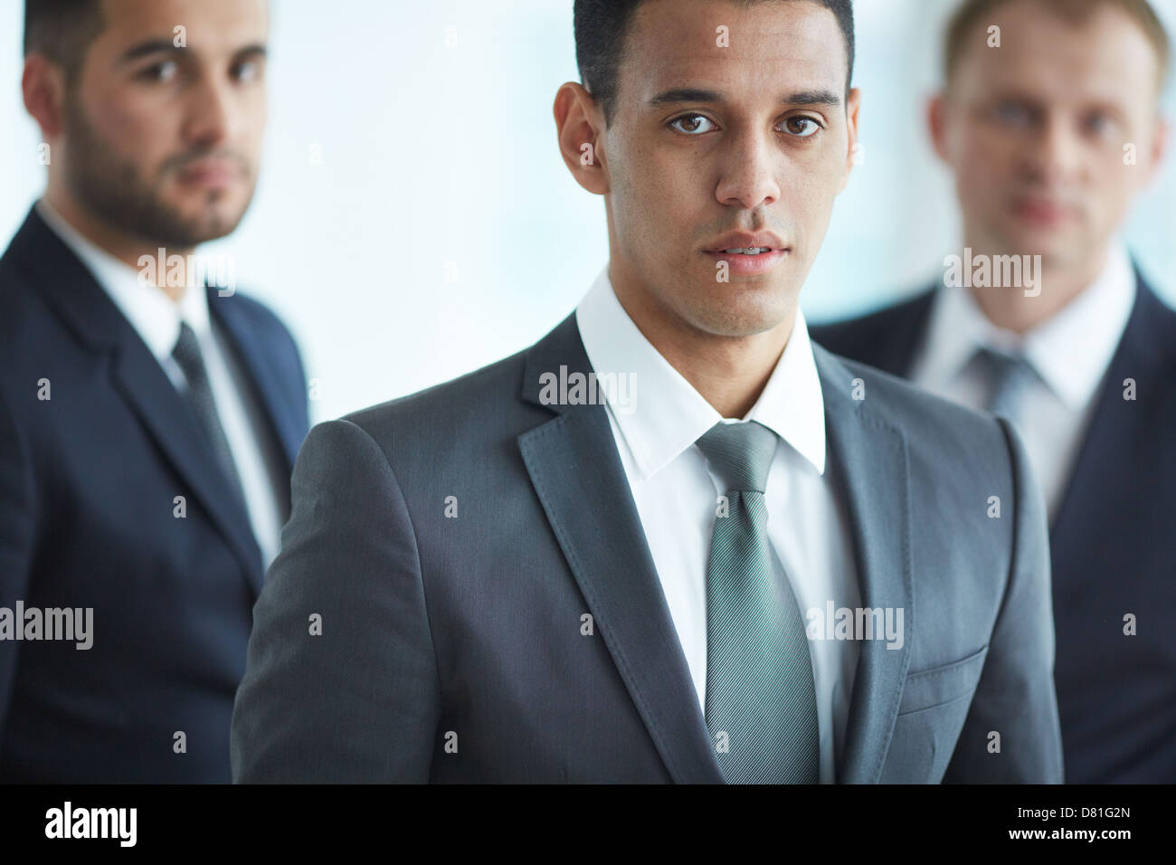 Portrait of confident businessmen looking at camera with young leader ...