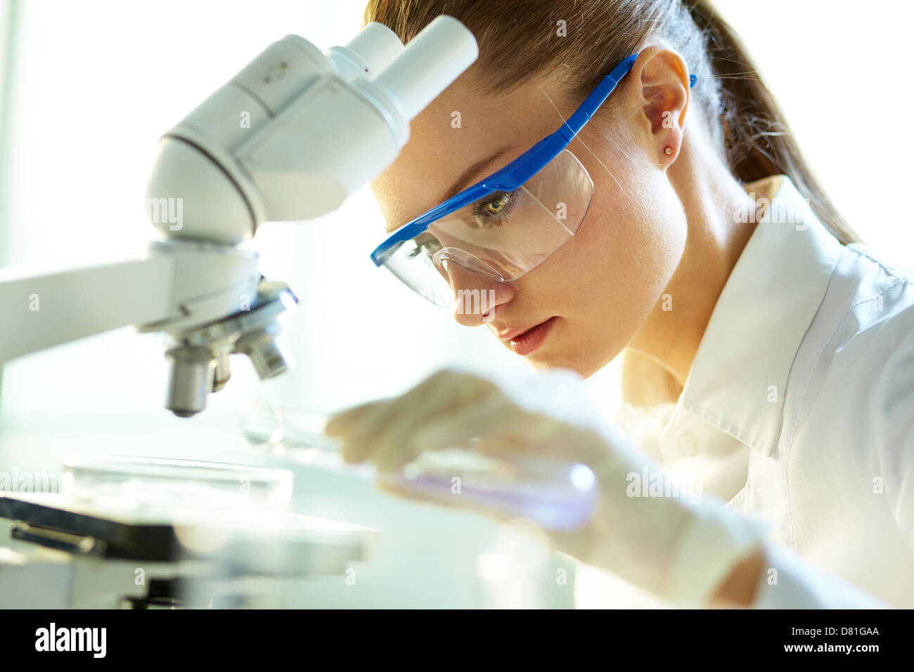 Female biochemist mixing substances to study under the microscope Stock ... Female biochemist mixing substances to study under the microscope Stock ...