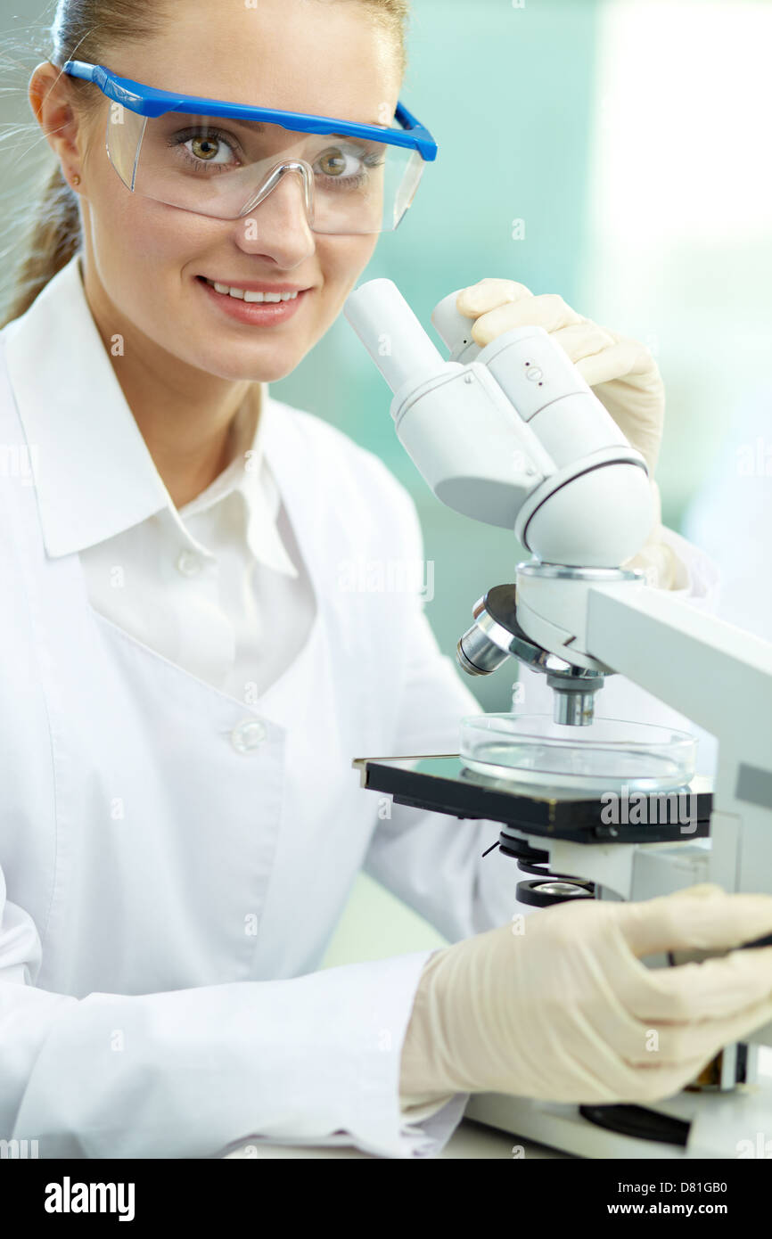 Pretty female with microscope looking at camera in laboratory Stock ...