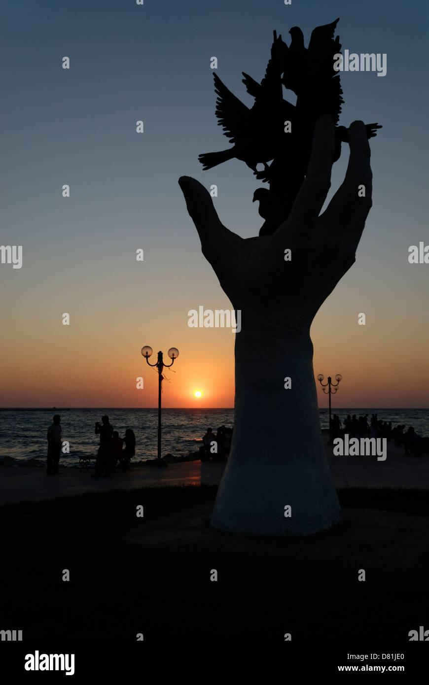 Turkey. Kusadasi. Hand of peace sculpture with doves is silhouetted ...