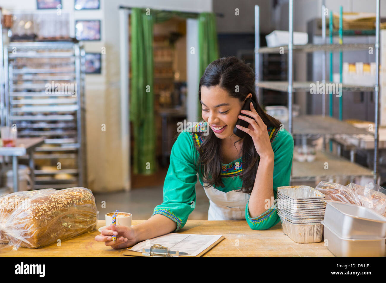 Mixed race woman working in bakery kitchen Stock Photo - Alamy
