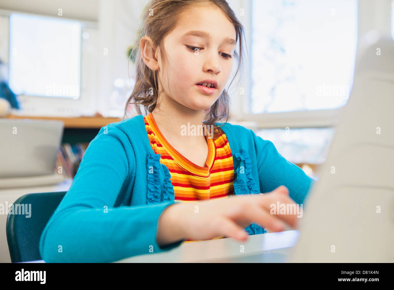 Caucasian girl using laptop in library Stock Photo - Alamy