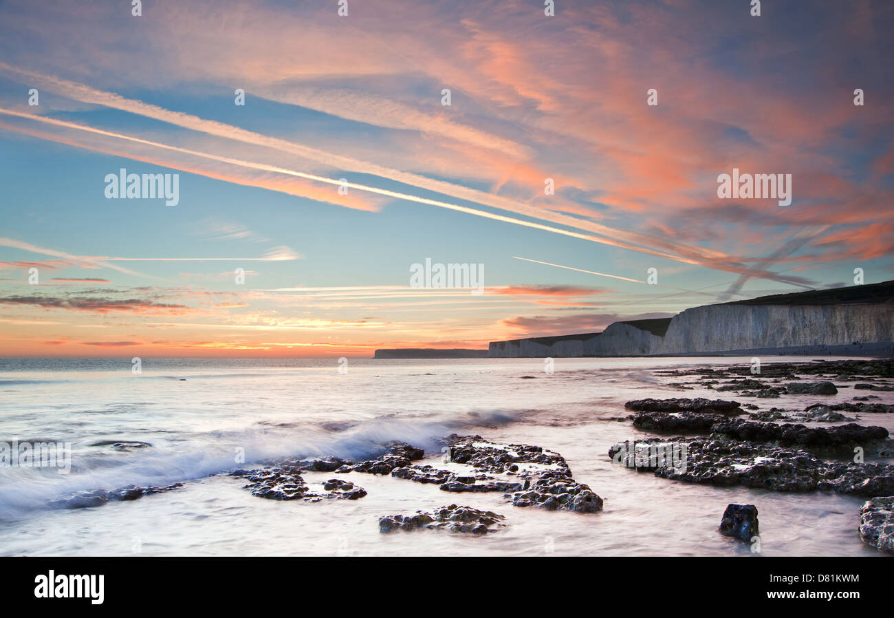 Stunning Summer sunset over ocean with cliffs, rocks and vibrant colors ...