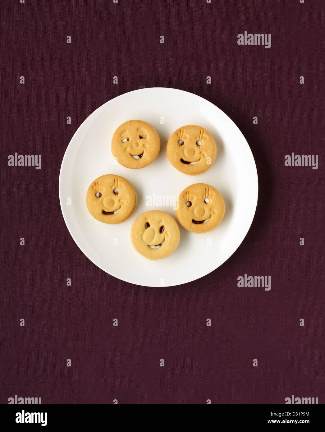 smiley face biscuits on a white plate with a dark background Stock ...
