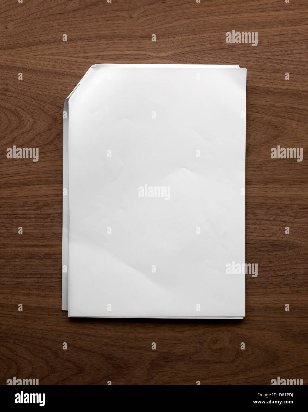 sheets of plain white paper stapled at the corner and folded over lying ...