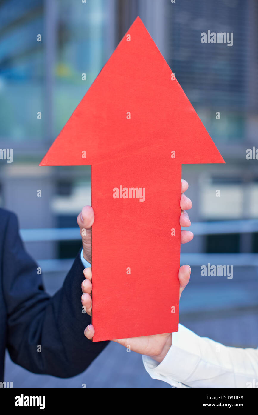 Hands holding a red arrow pointing up Stock Photo - Alamy