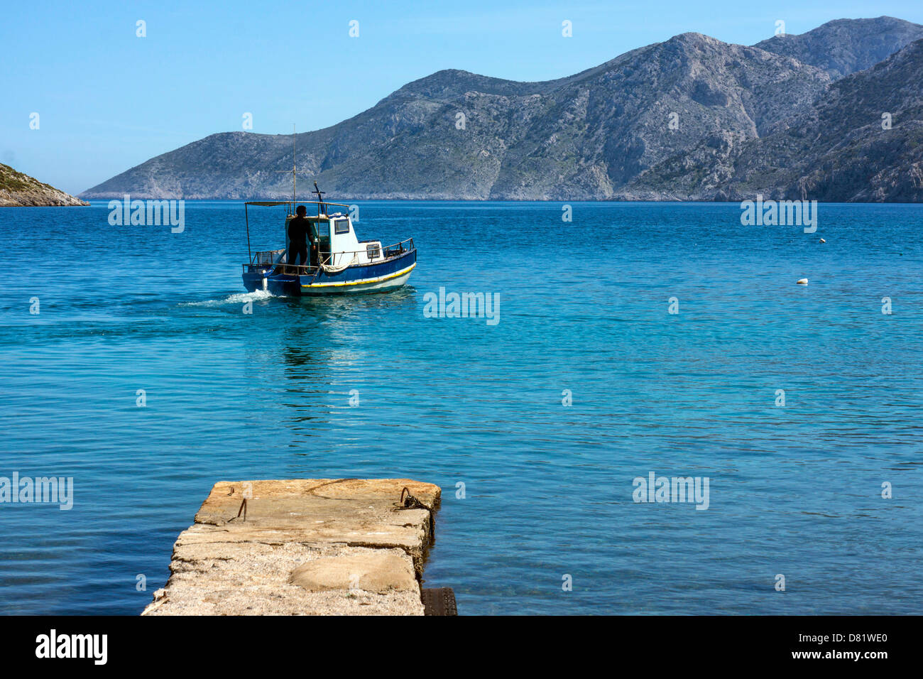 Small fishing boat with stone jetty pier, blue sea, blue sky, Aegean ...