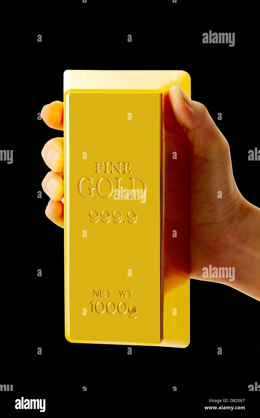 Hand holding a piece of gold Stock Photo - Alamy