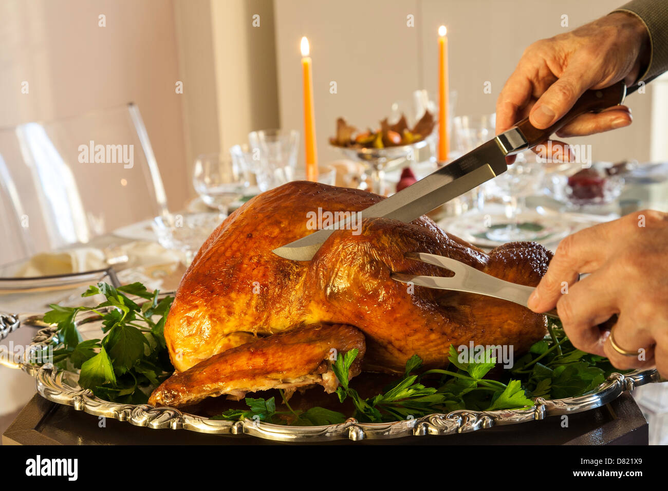 Man Carves Turkey at Formal Residential Dining Room Table Set for ...