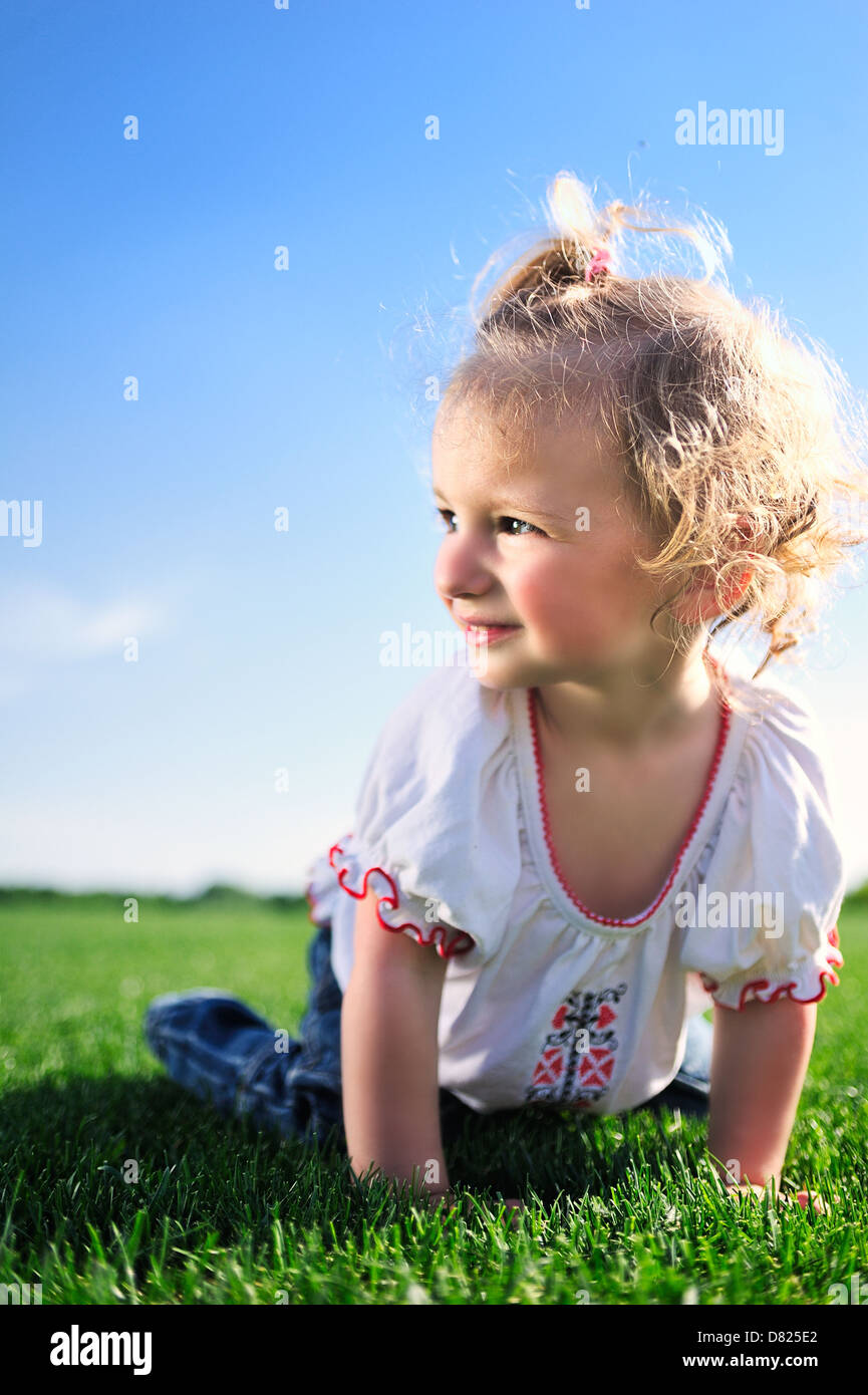 Cute little girl crawling on the green grass in the park Stock Photo ...