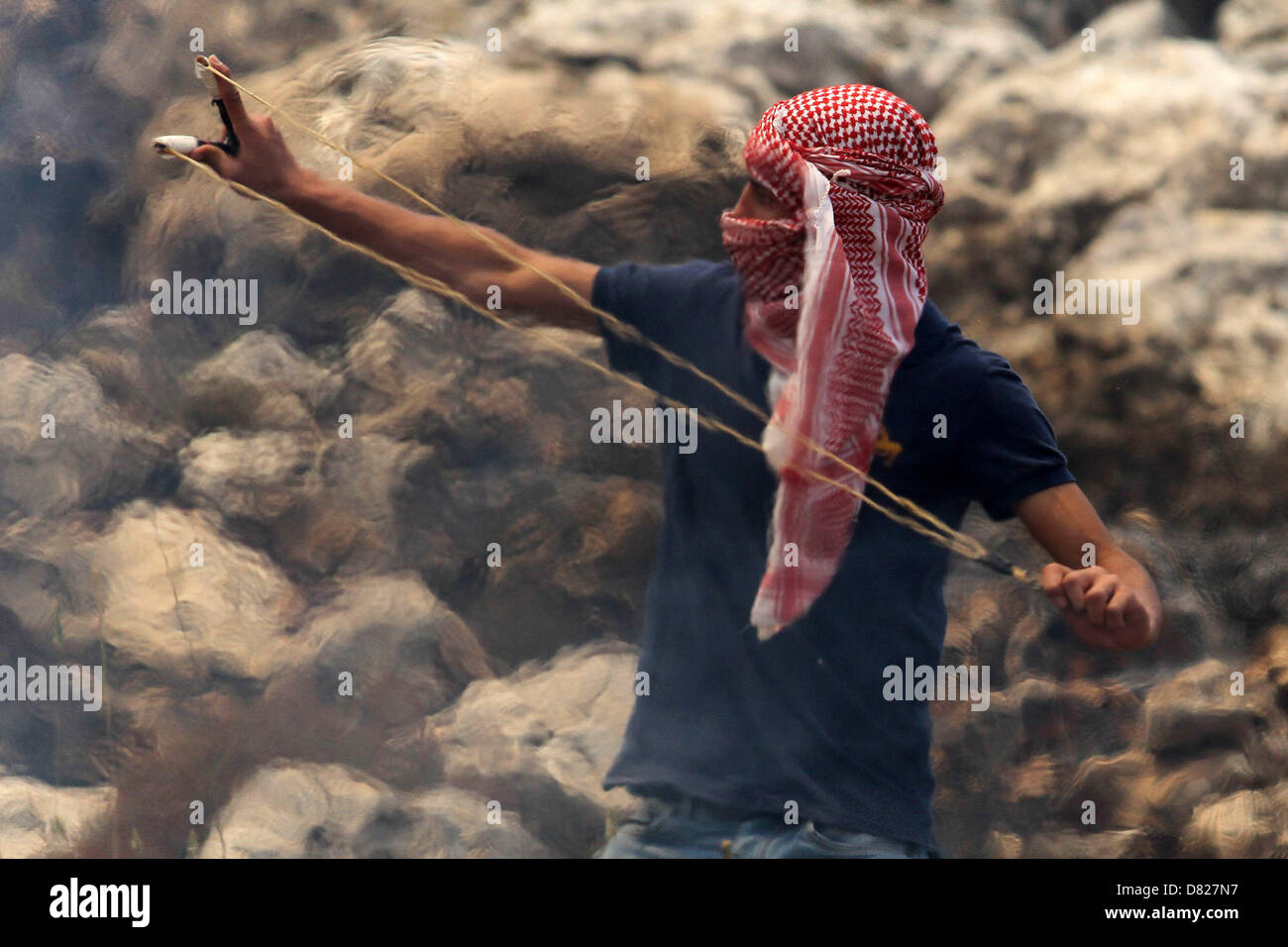 May 17, 2013 - Ramallah, West Bank - A Palestinian hurls rocks from a ...