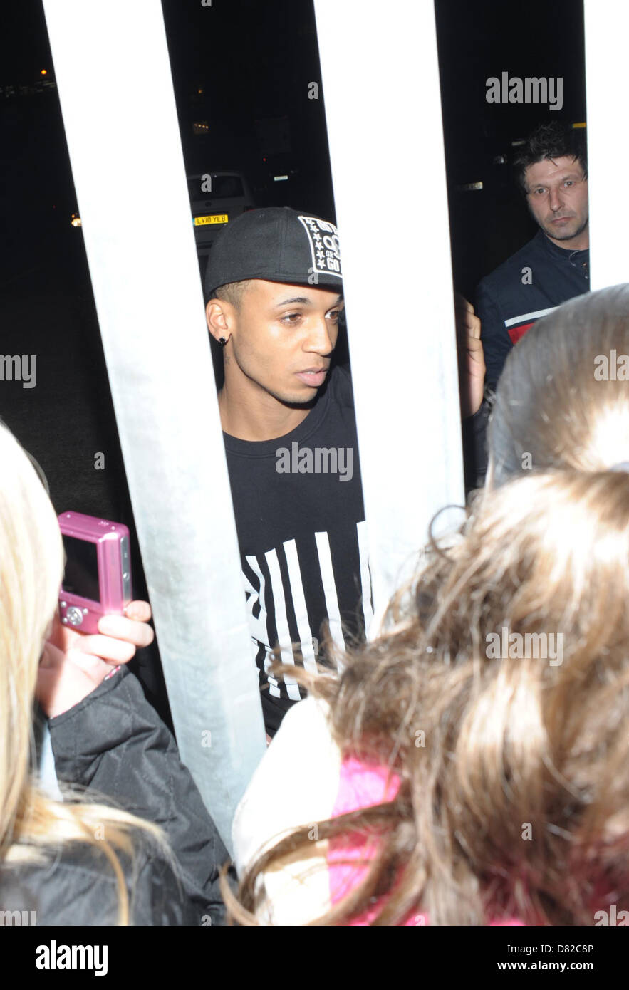 Aston Merrygold of JLS signs autographs for waiting fans outside a ...