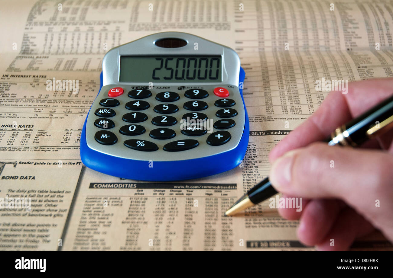 Checking the figures in the Financial Times, UK Stock Photo - Alamy