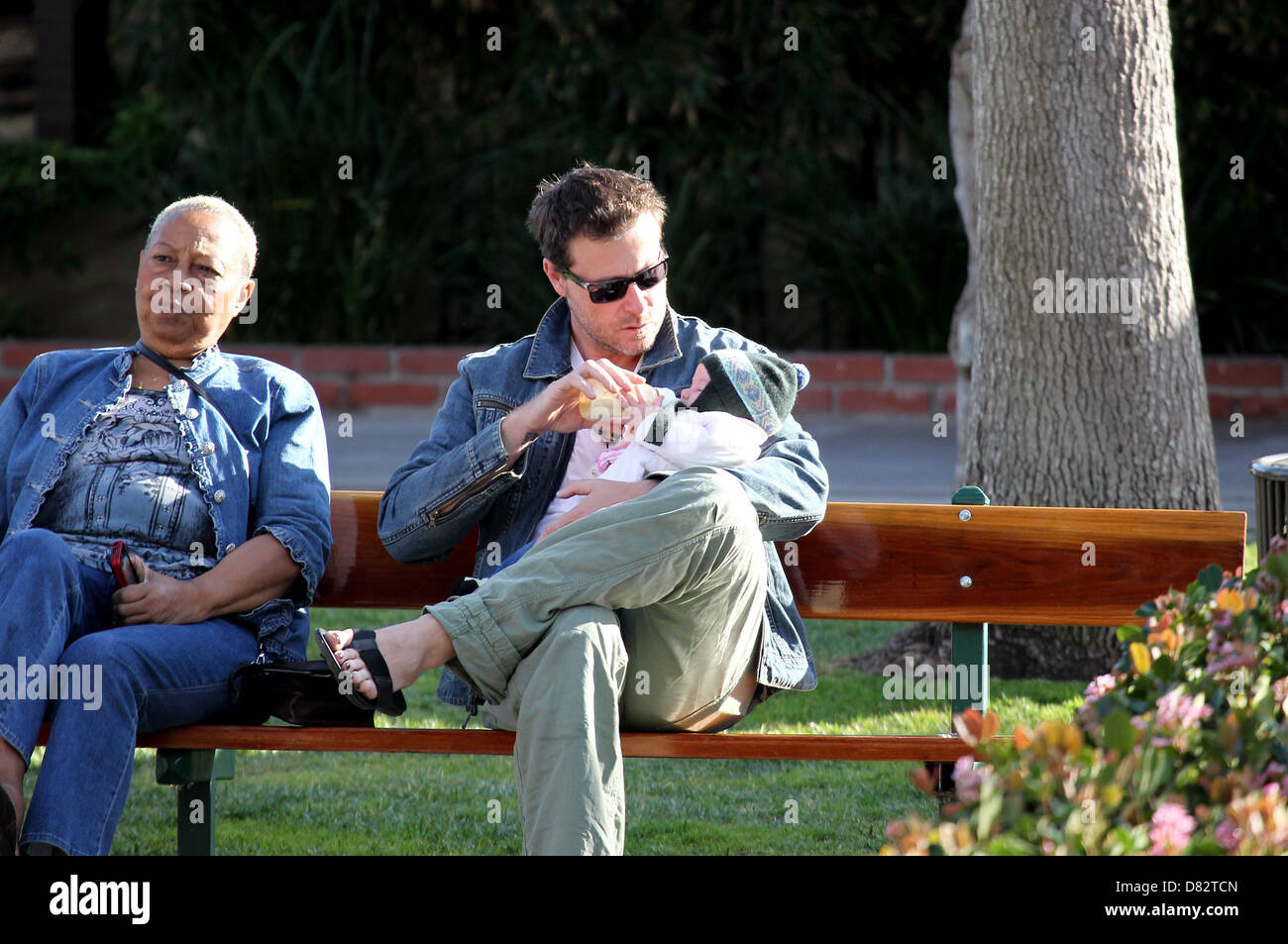 Dean McDermott feeds his daughter Hattie on a bench at Malibu Park ...