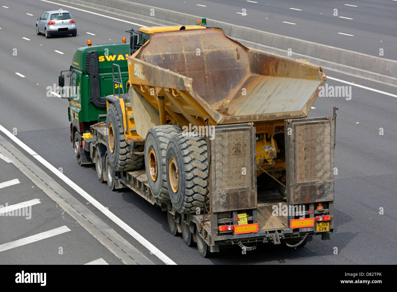 Dump truck being transported by hgv lorry on a low loader articulated ...