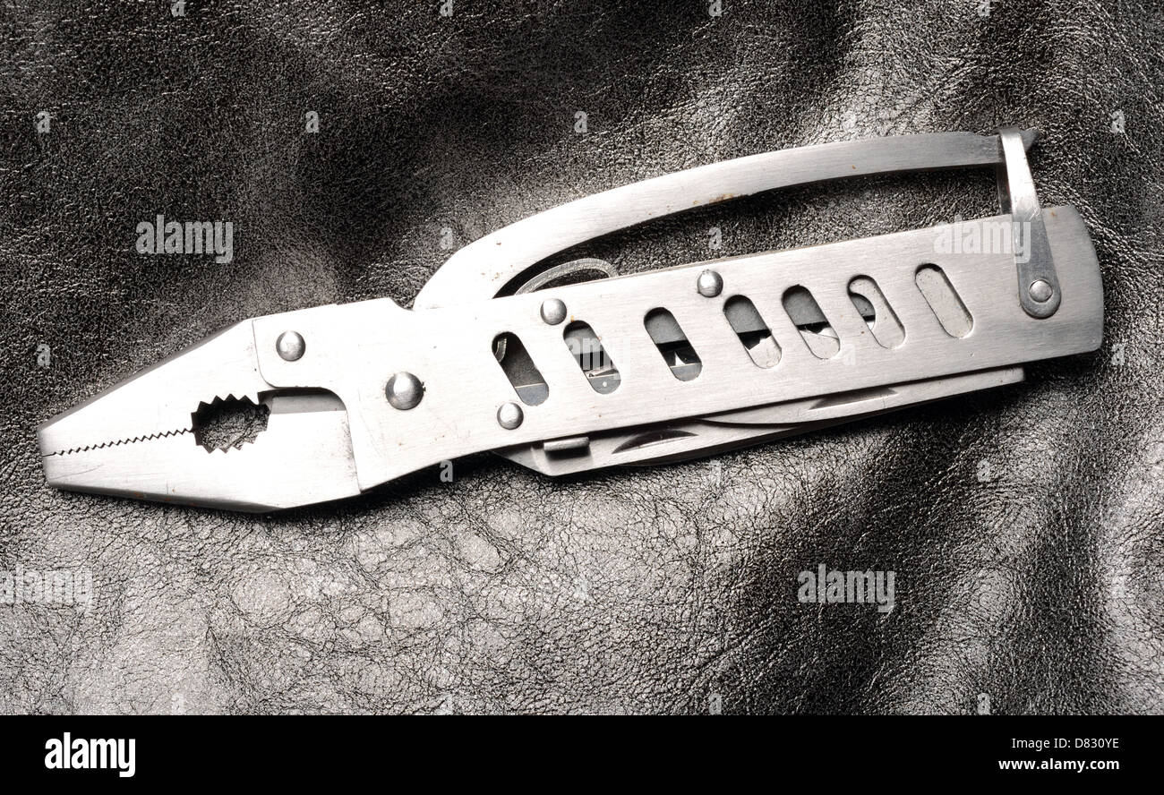 Multi-purpose tool on gray textured background Stock Photo - Alamy