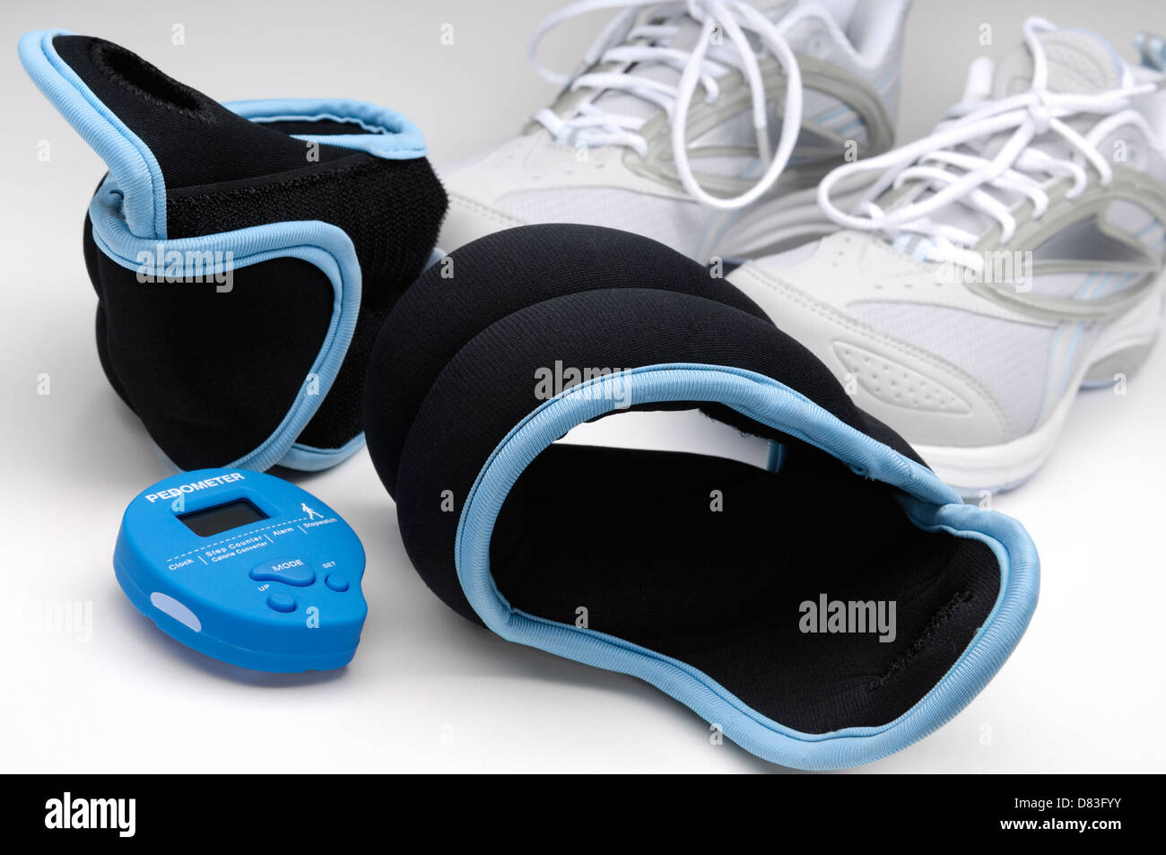Exercise wrist weights, pedometer and running shoes still life Stock ...