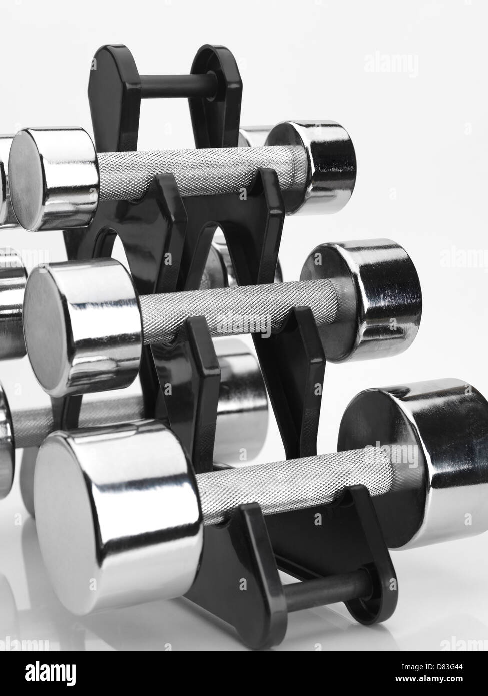 Rack with a set of shiny chrome dumbbells isolated on white background ...