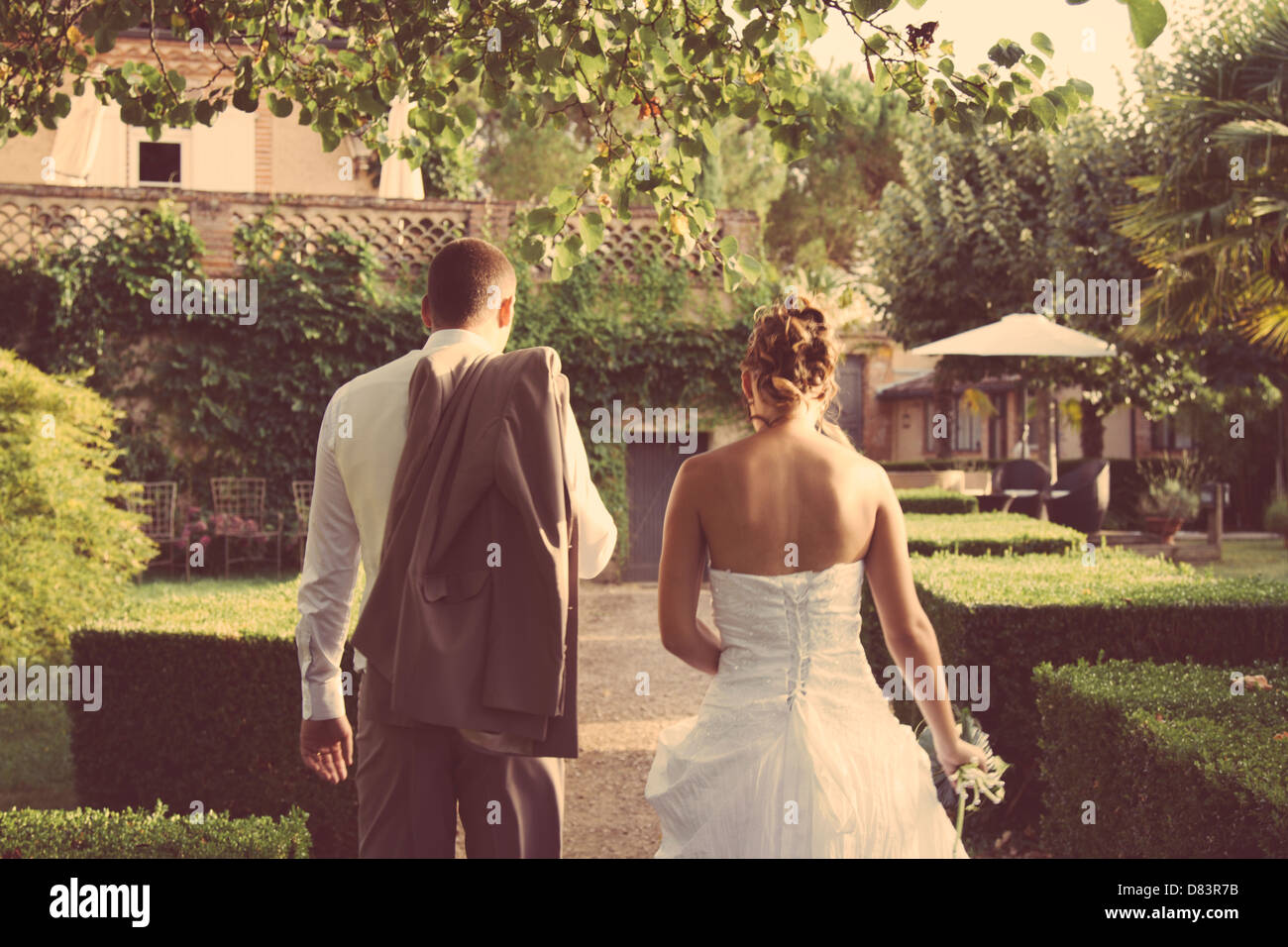 Just married couple walking in alleyway Stock Photo - Alamy