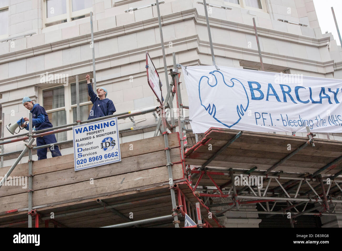 London, UK. 18th May 2013. London Two protesters atop a scaffold ...