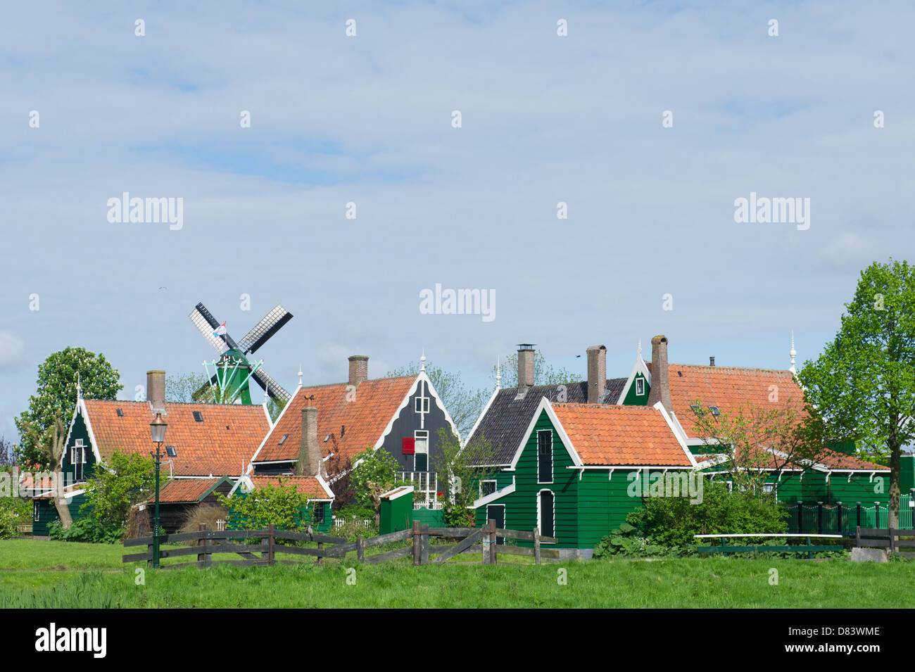 Typical Dutch village with green wooden houses and windmill Stock Photo ...