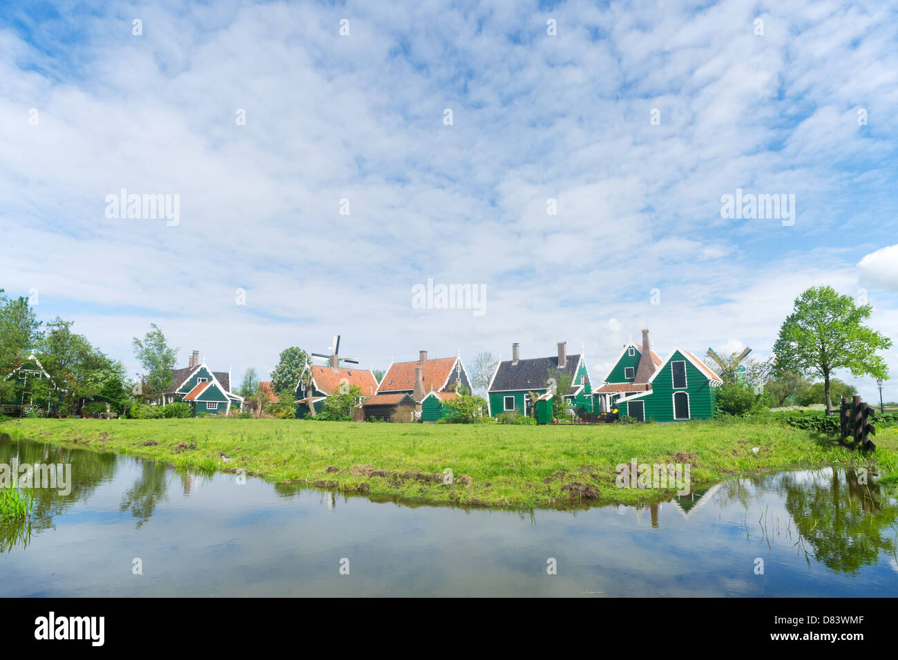 Typical Dutch village with green wooden houses and windmill Stock Photo ...