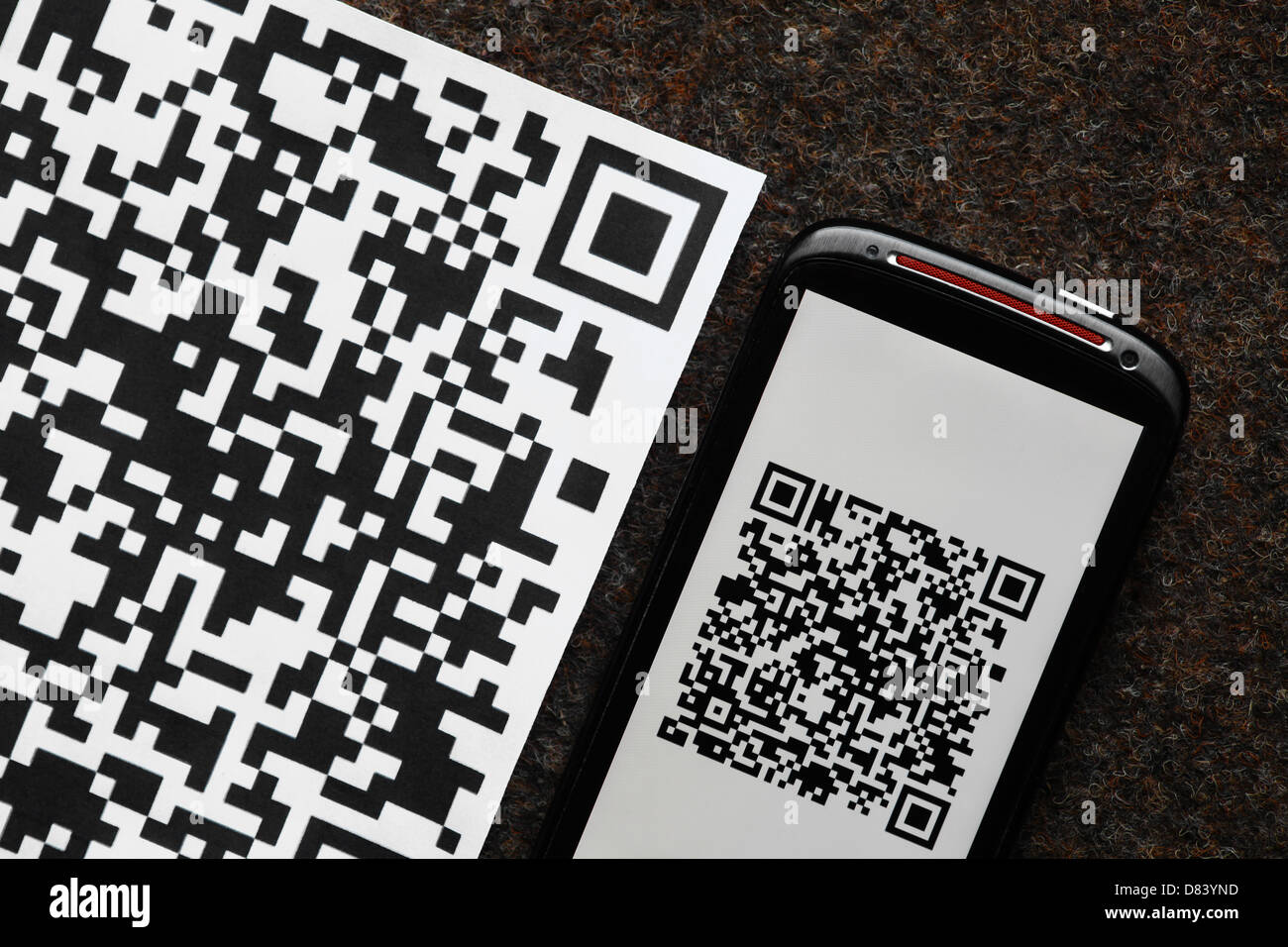 A mobile phone next to a QR code printed on paper Stock Photo - Alamy