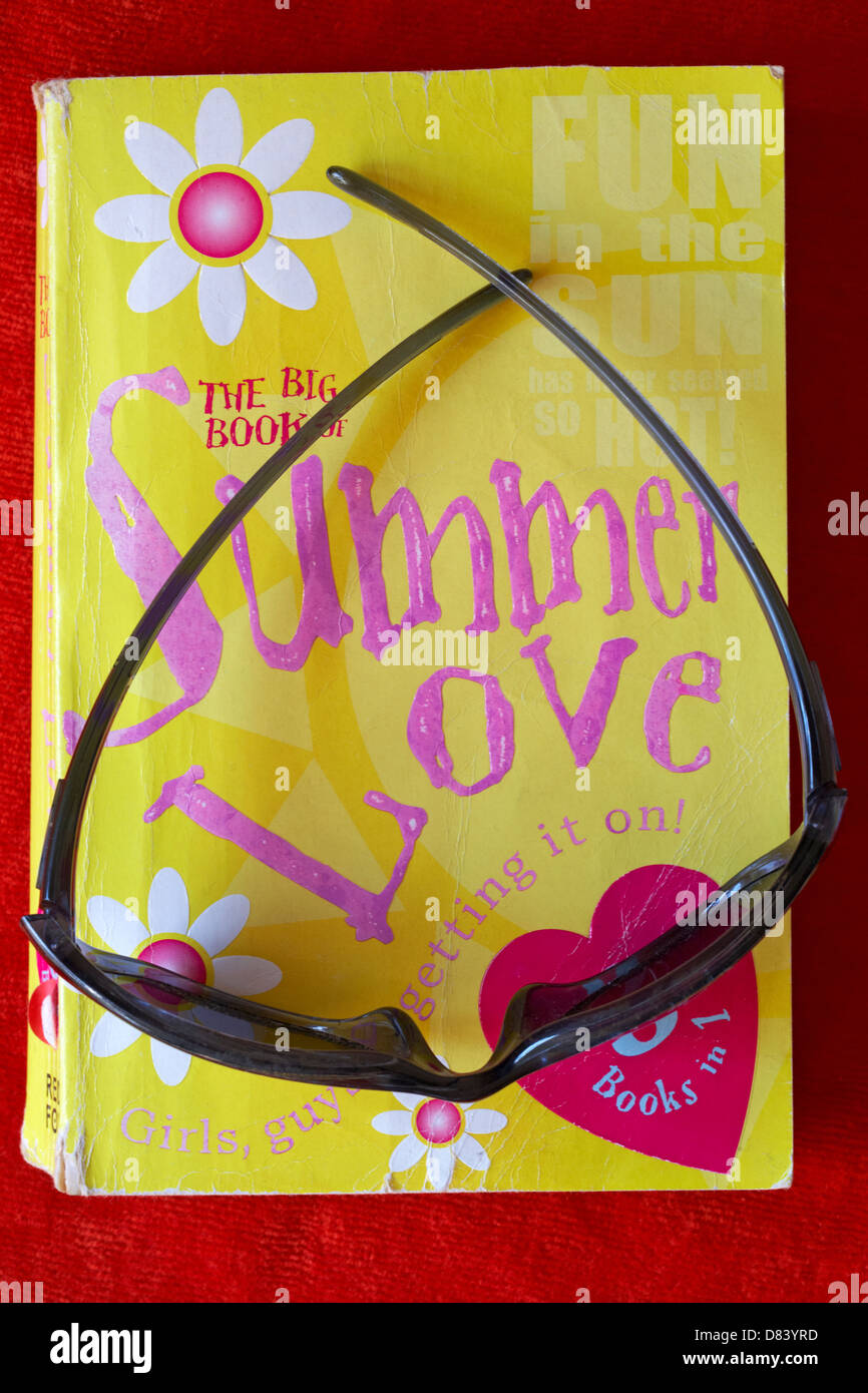 The big book of Summer Love book and sunglasses on orange towel ...
