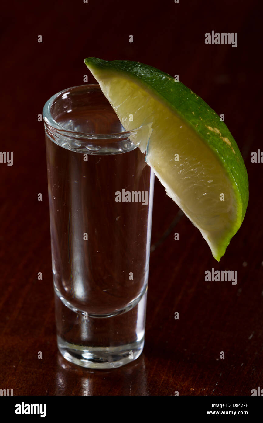 silver tequila served in a tall glass with a lime on top Stock Photo ...