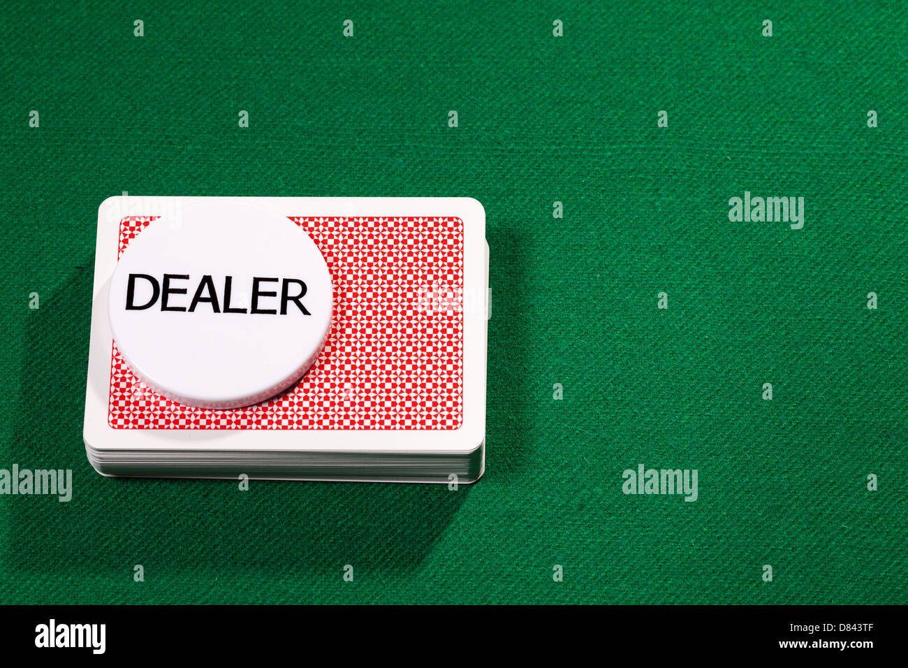 Poker cards with dealer chip on green cloth Stock Photo - Alamy