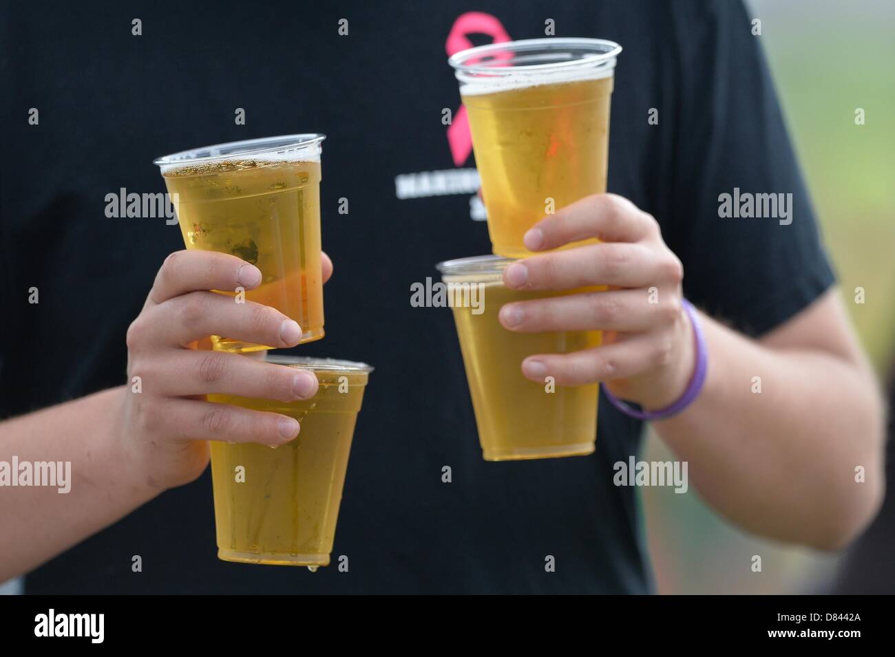 Baltimore, USA. 18th May, 2013. A racing fan balances a few beers in ...