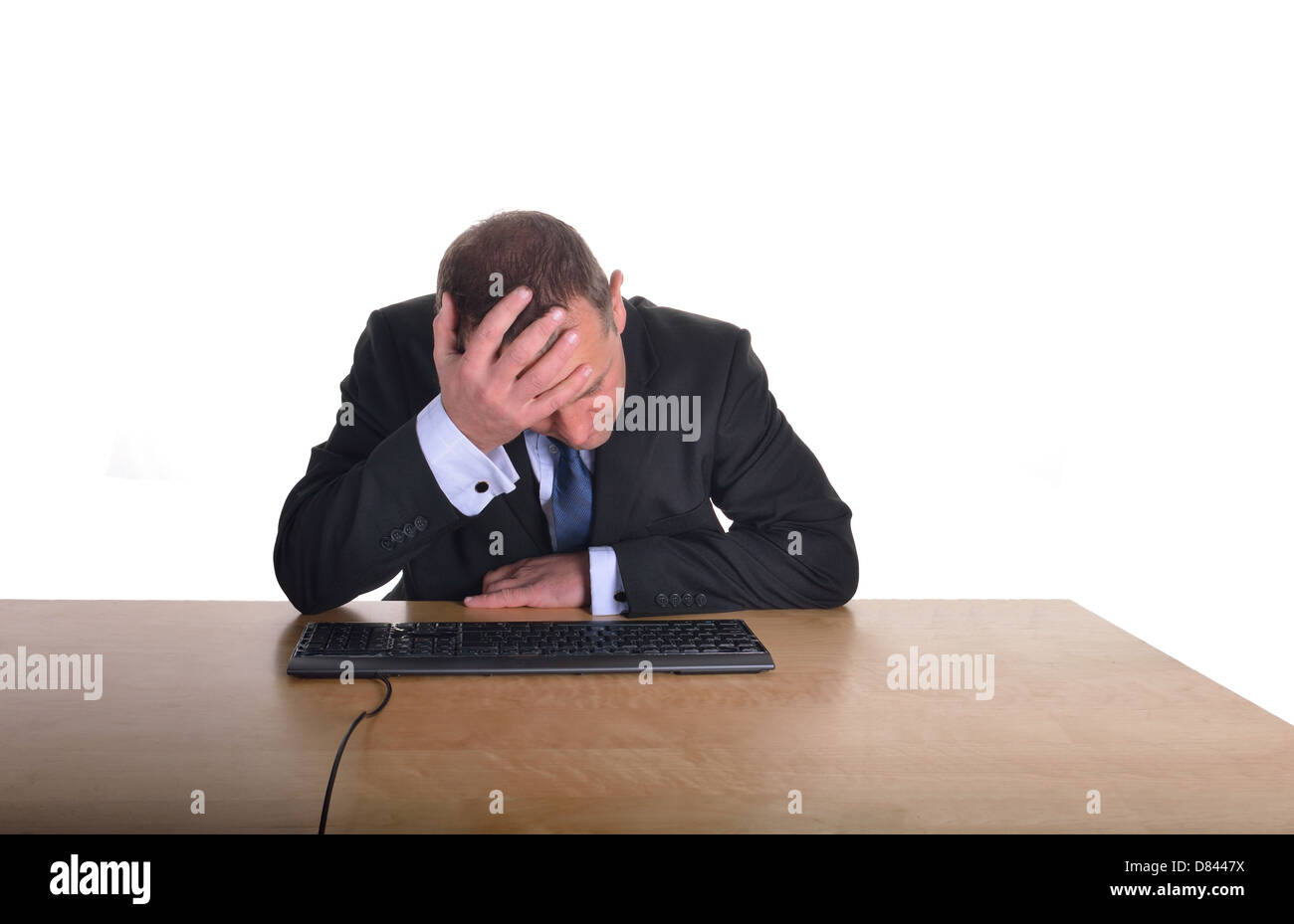 Image of a businessman in a stressed pose at a desk Stock Photo - Alamy