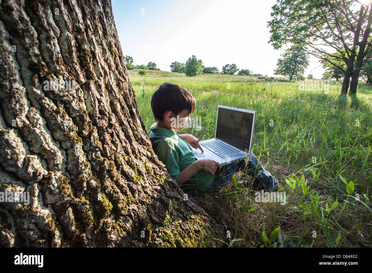 boy using his laptop outdoor in park on grass Stock Photo - Alamy