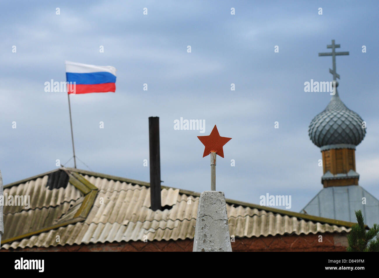 A Russian flag, red star and orthodox cross in the cloudy sky. Siberia ...