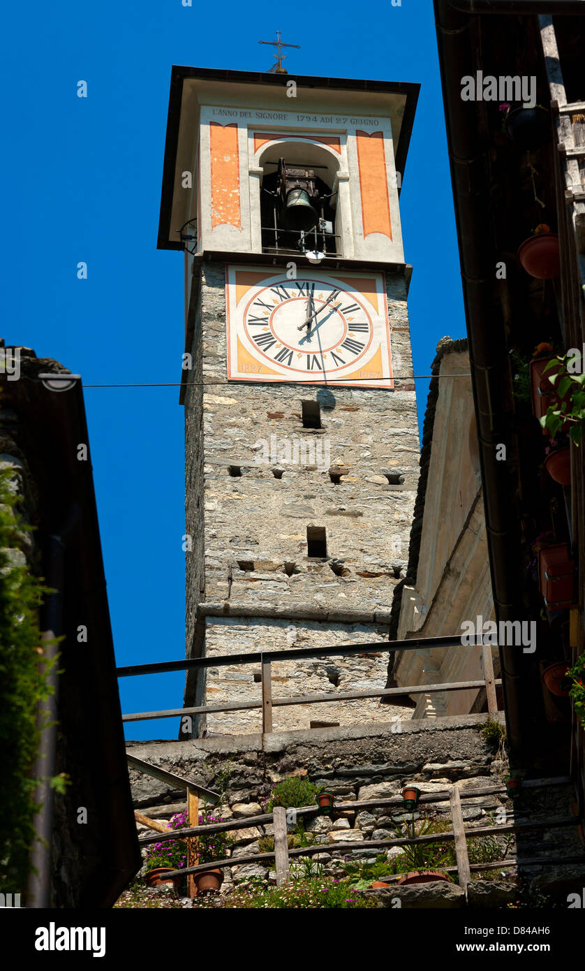 The clock tower of the parish church in the village of Corippo, Ticino ...