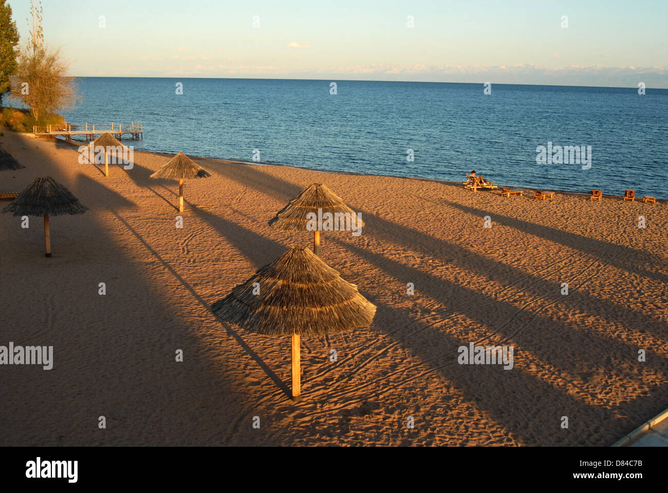 Few shelters at the beach of the Issyk Kul lake an the sunset. Issyk ...
