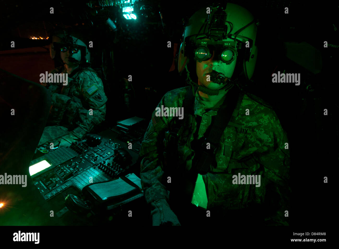 Pilots equipped with night vision goggles in the cockpit of a UH-60 ...