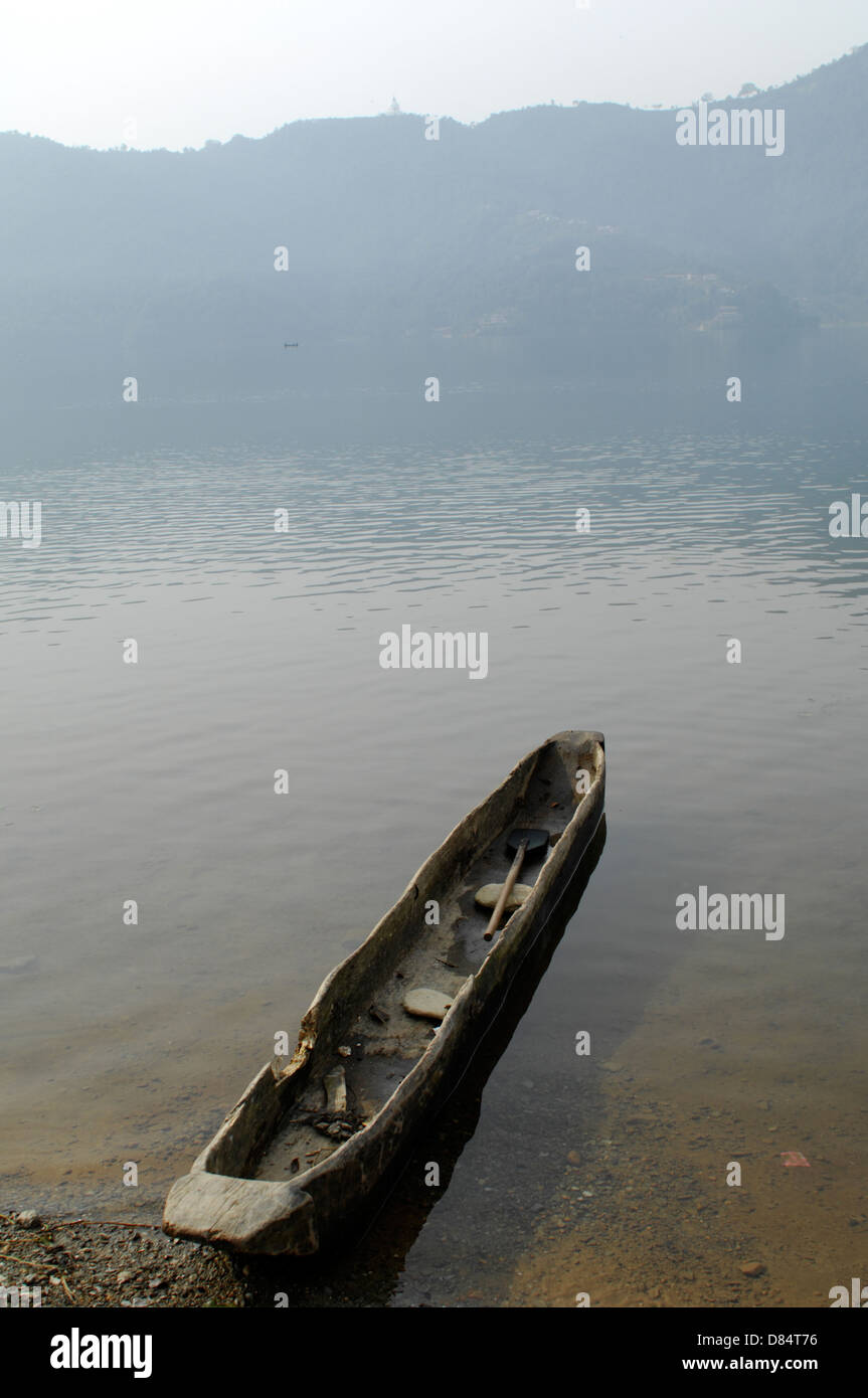 a dugout canoe on Fewa Tal lake in Phokara, Nepal. The canoe is carved ...