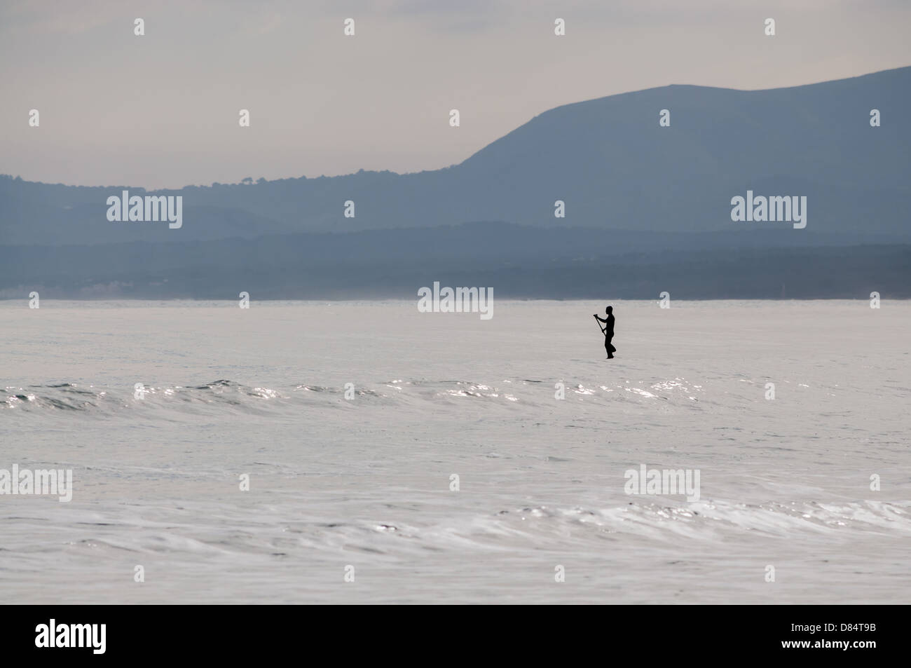 Solo paddle surfer paddling away in Alcudia Bay, Majorca winter Stock ...