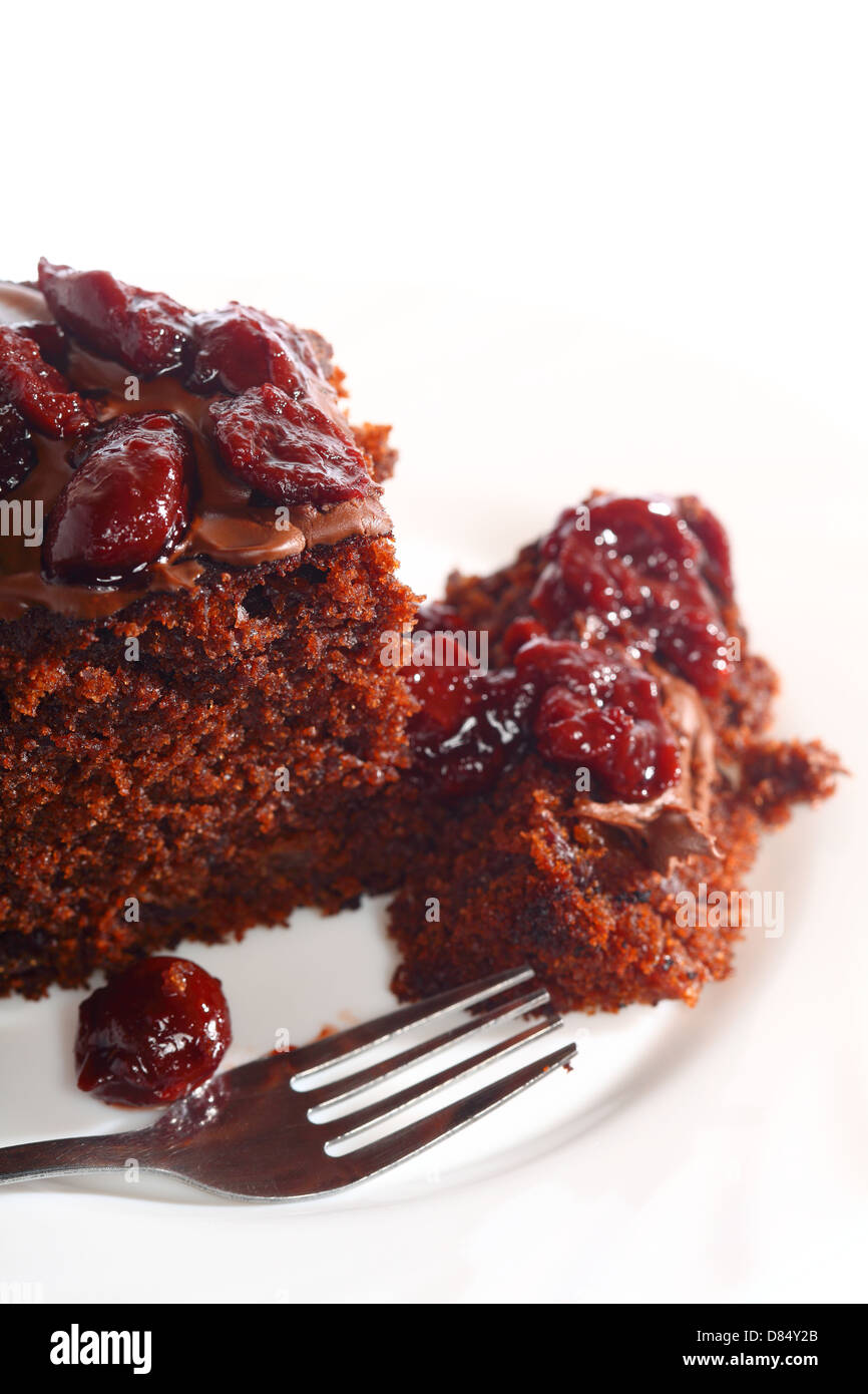 Piece of chocolate cake with icing and cherry on white isolated ...