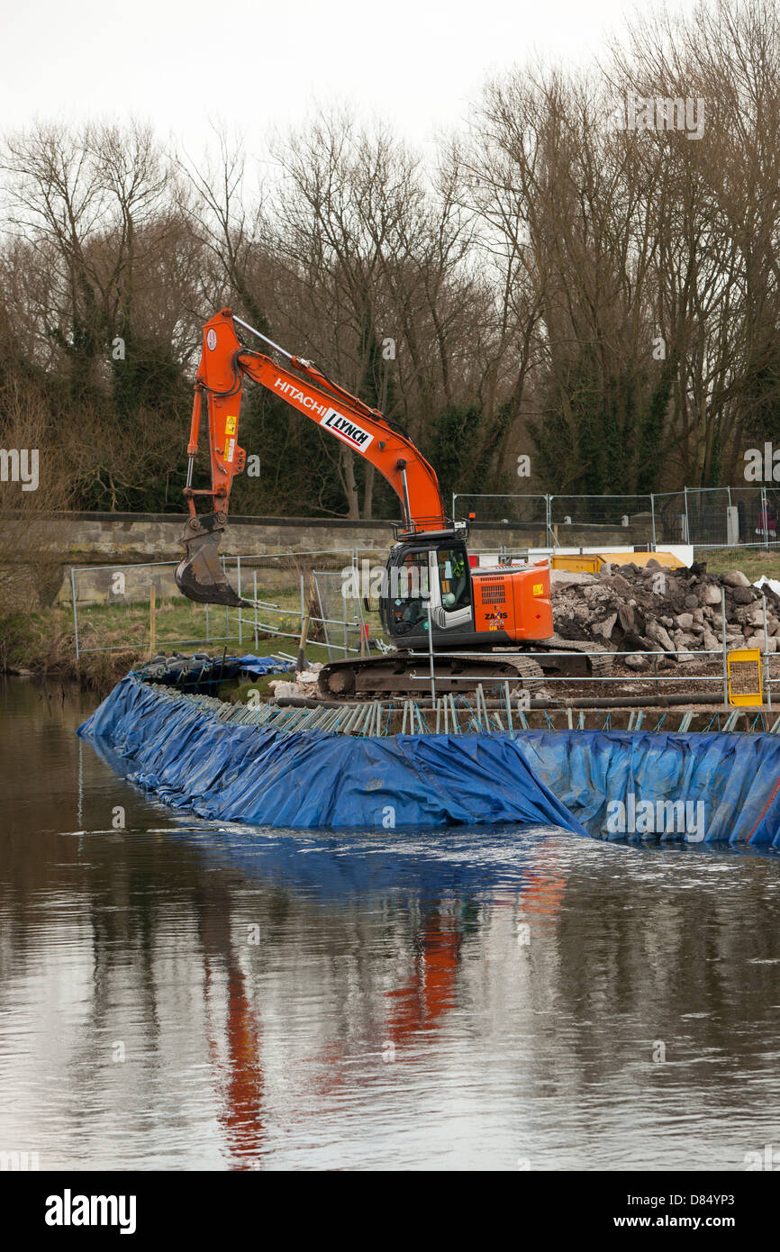 An Hitachi mechanical digger working on constructing a fish pass Stock ...