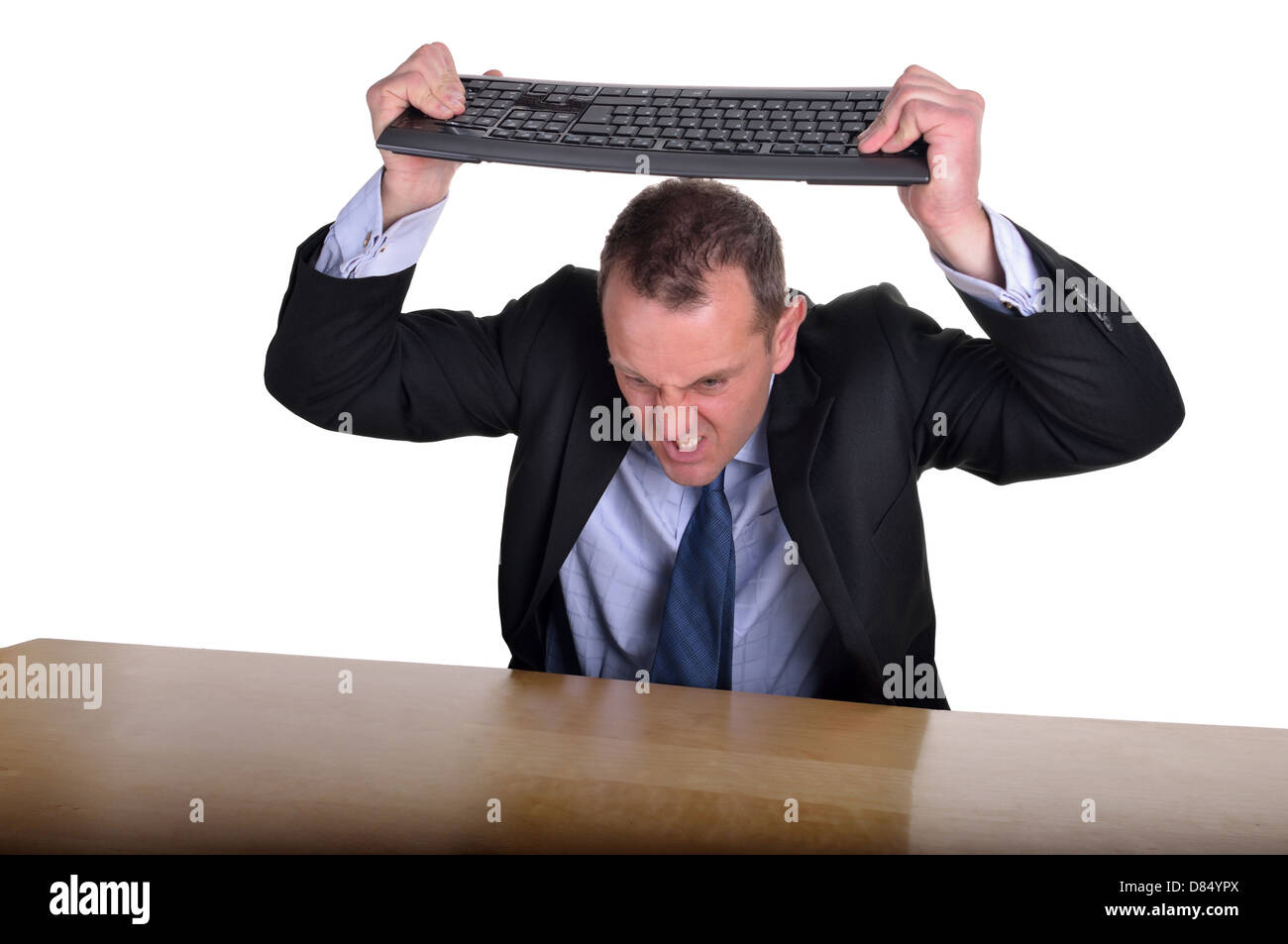 Image of a businessman sitting at a desk about to break a keyboard in ...